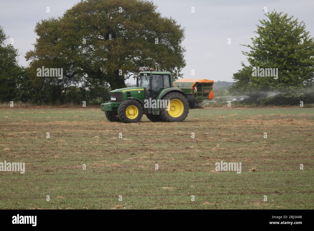 Tractor fertilizing fields Stock Photo - Alamy