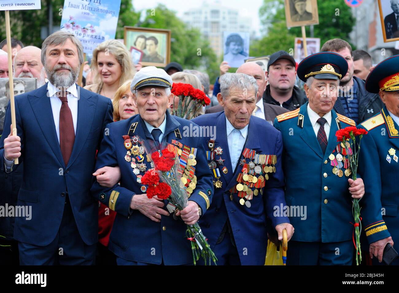 Veterans of the Great Patriotic War walking down street with flowers ...