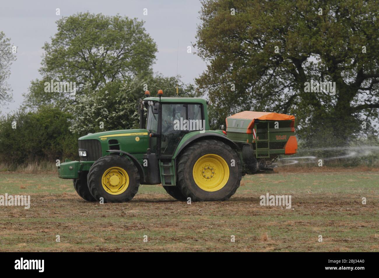 Tractor fertilizing fields Stock Photo - Alamy
