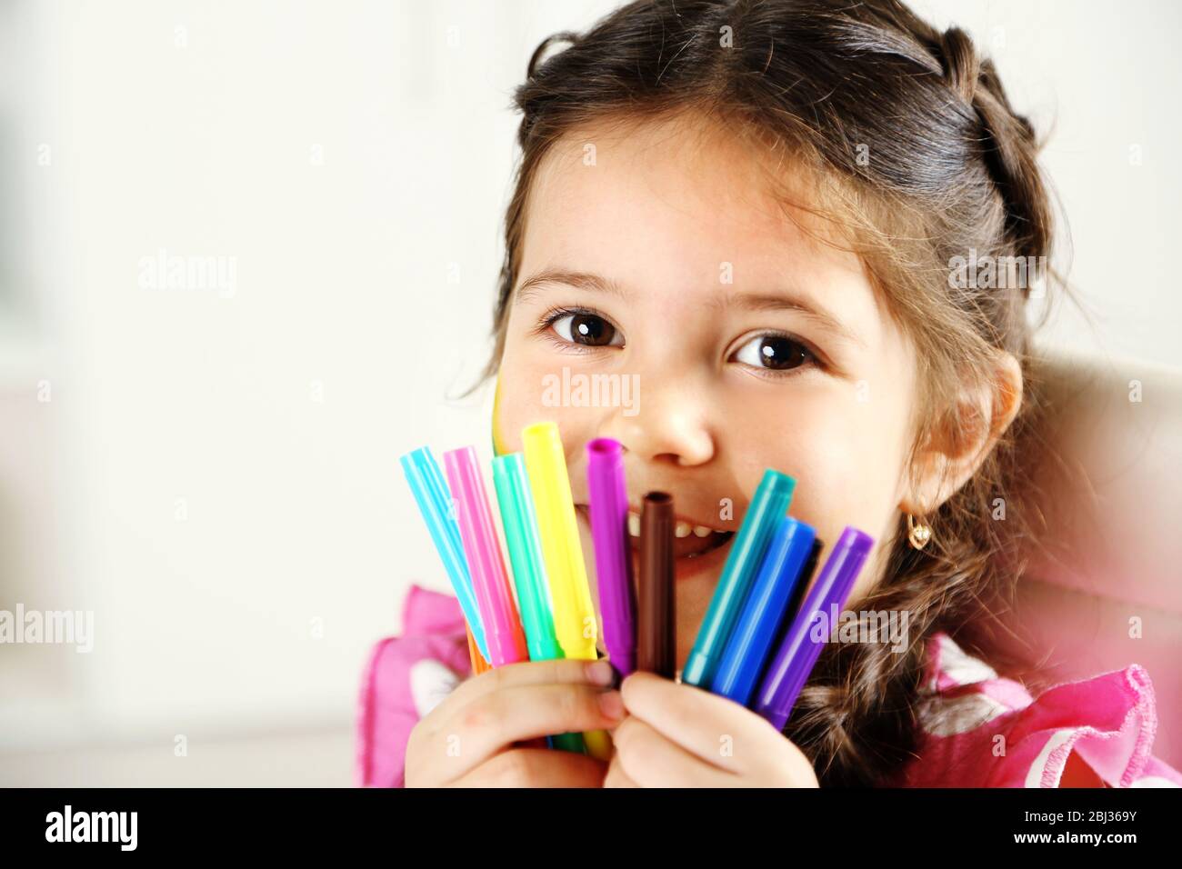 Cute little girl with colorful crayons, close-up Stock Photo - Alamy