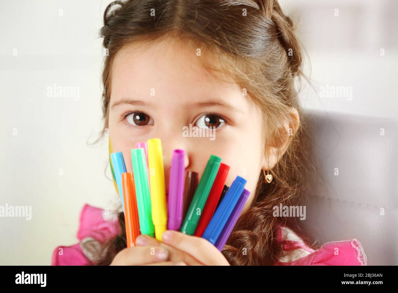 Cute little girl with colorful crayons, close-up Stock Photo - Alamy
