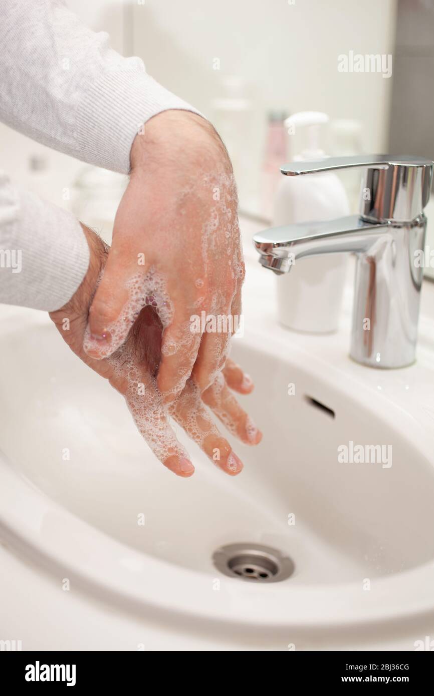 man washing hands with soap at home. coronavirus prevention hand ...