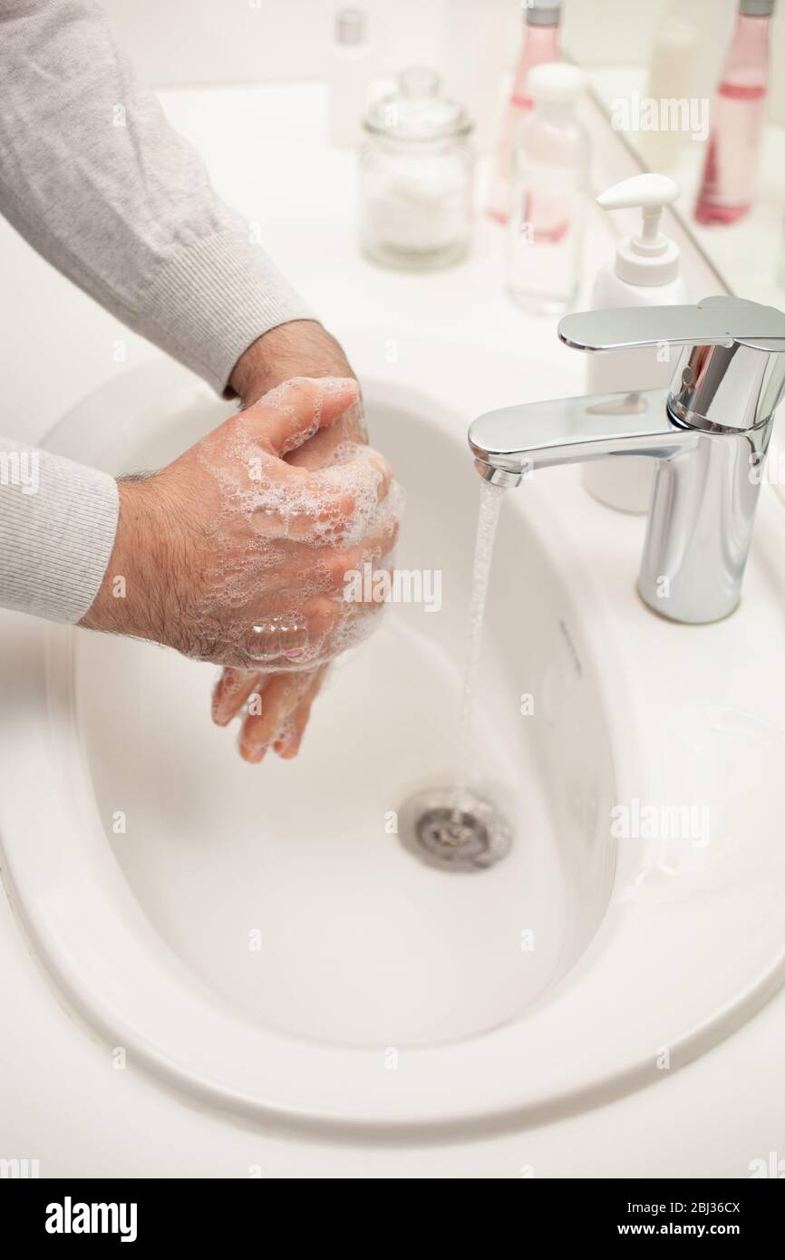 man washing hands with soap at home. coronavirus prevention hand ...