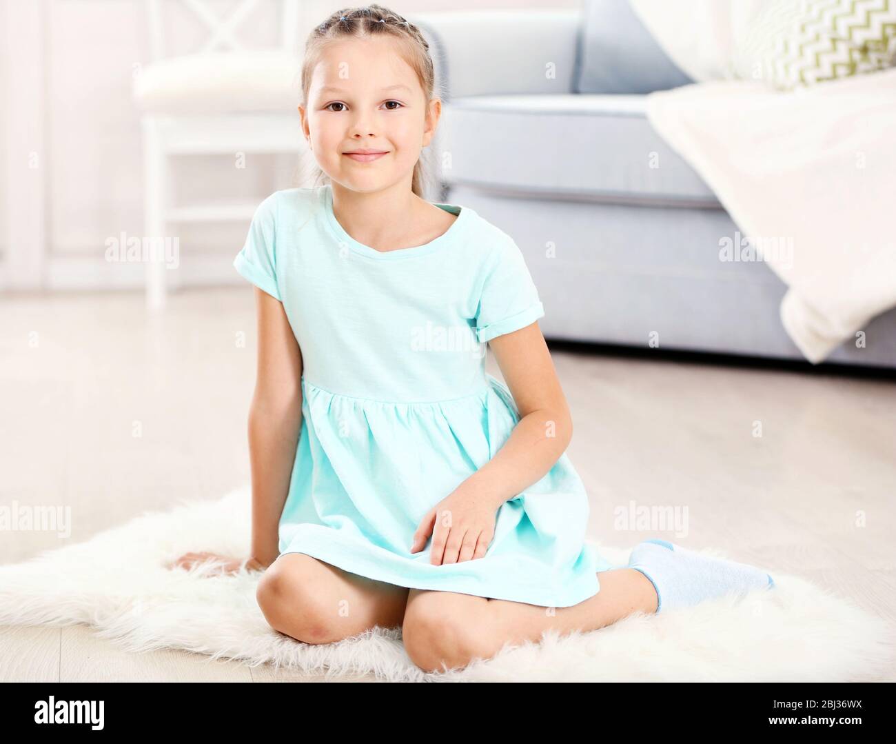 Little cute girl sitting on carpet, on home interior background Stock ...