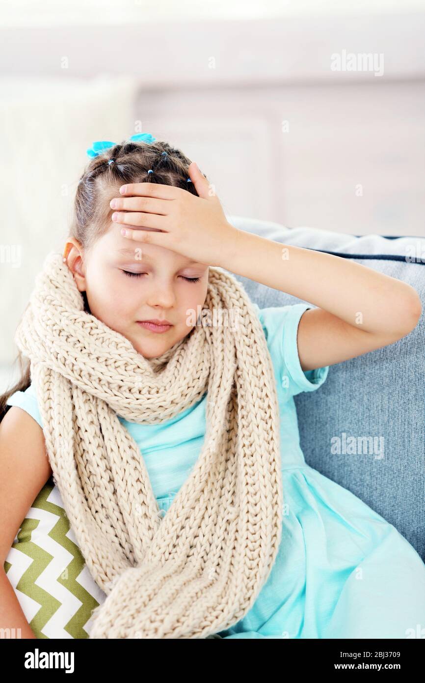 Sick girl with cold sitting on sofa Stock Photo - Alamy
