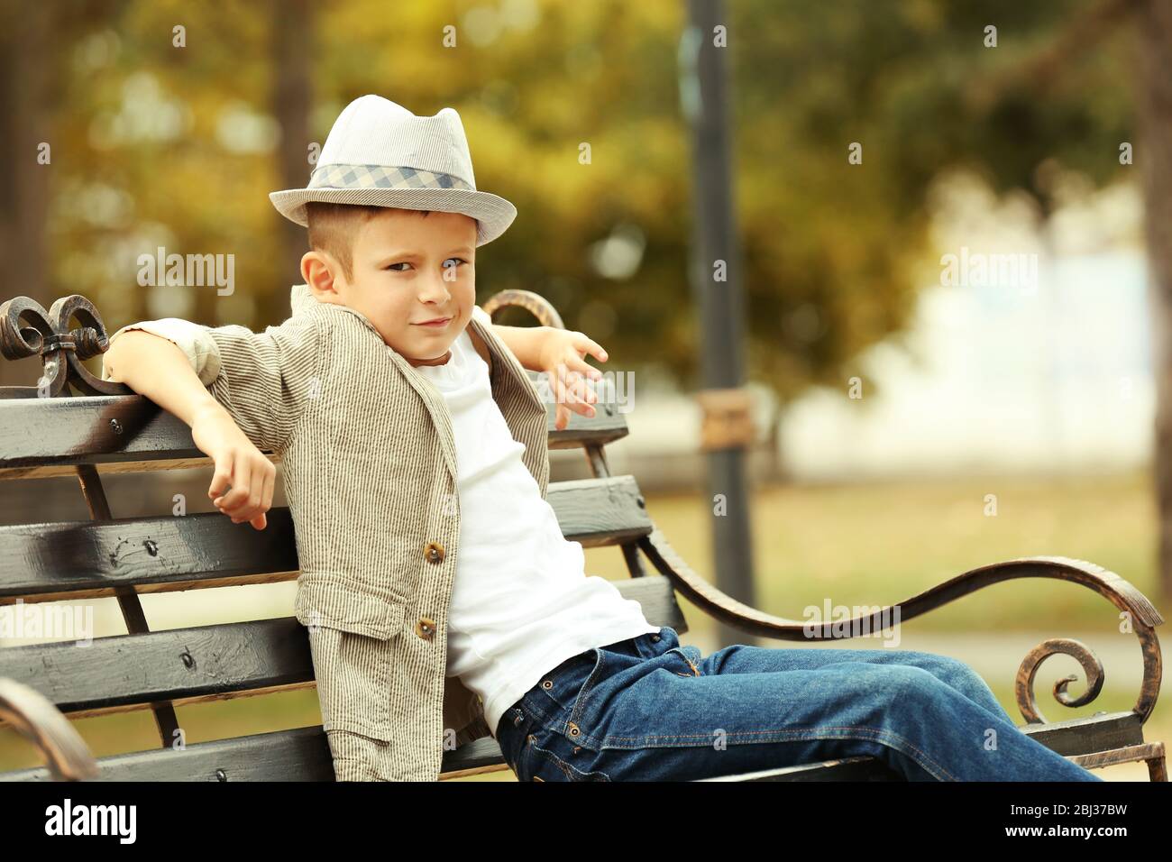 Little boy on bench in the park Stock Photo - Alamy