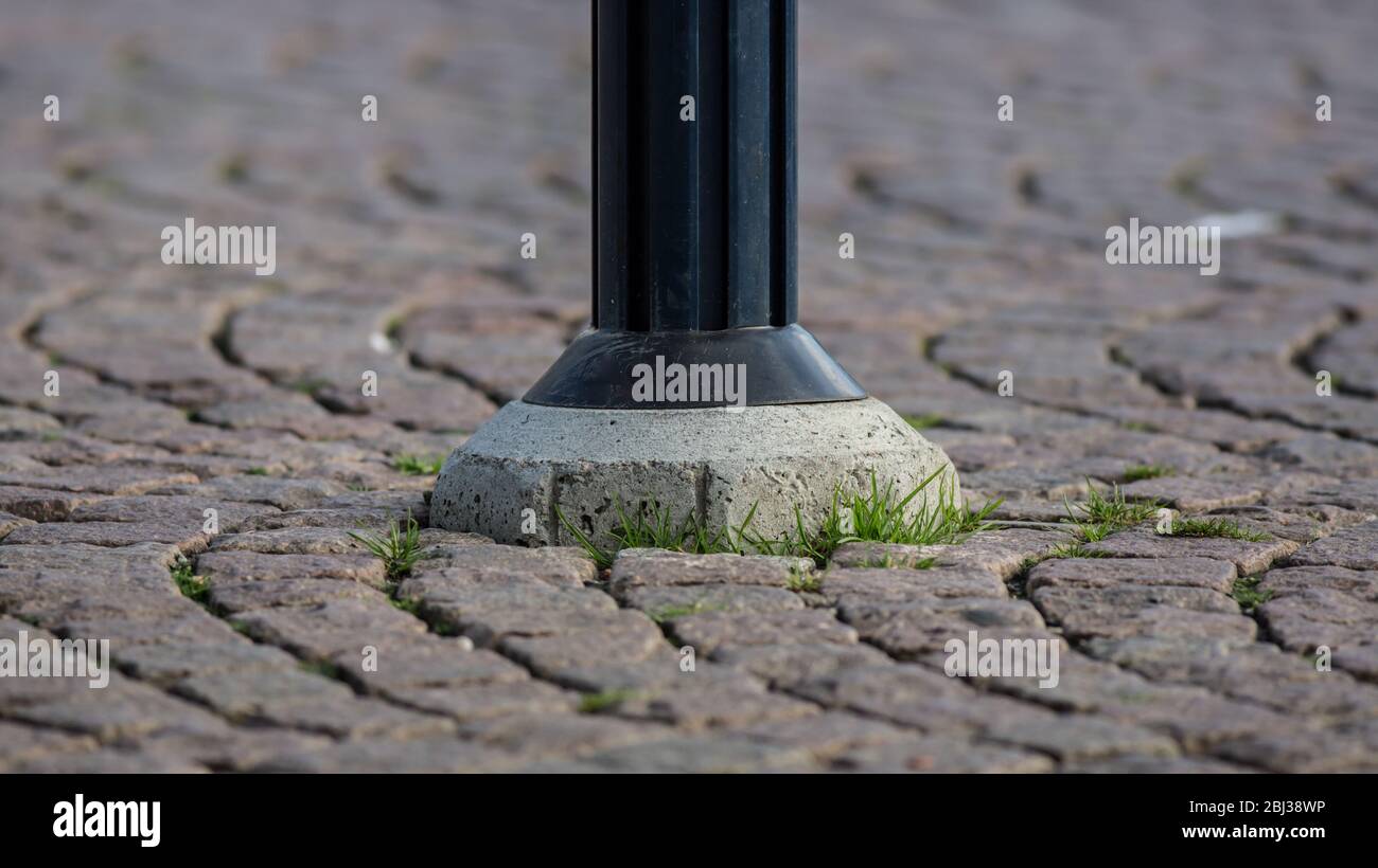 Cobblestone and the stone base of a steel pole Stock Photo - Alamy