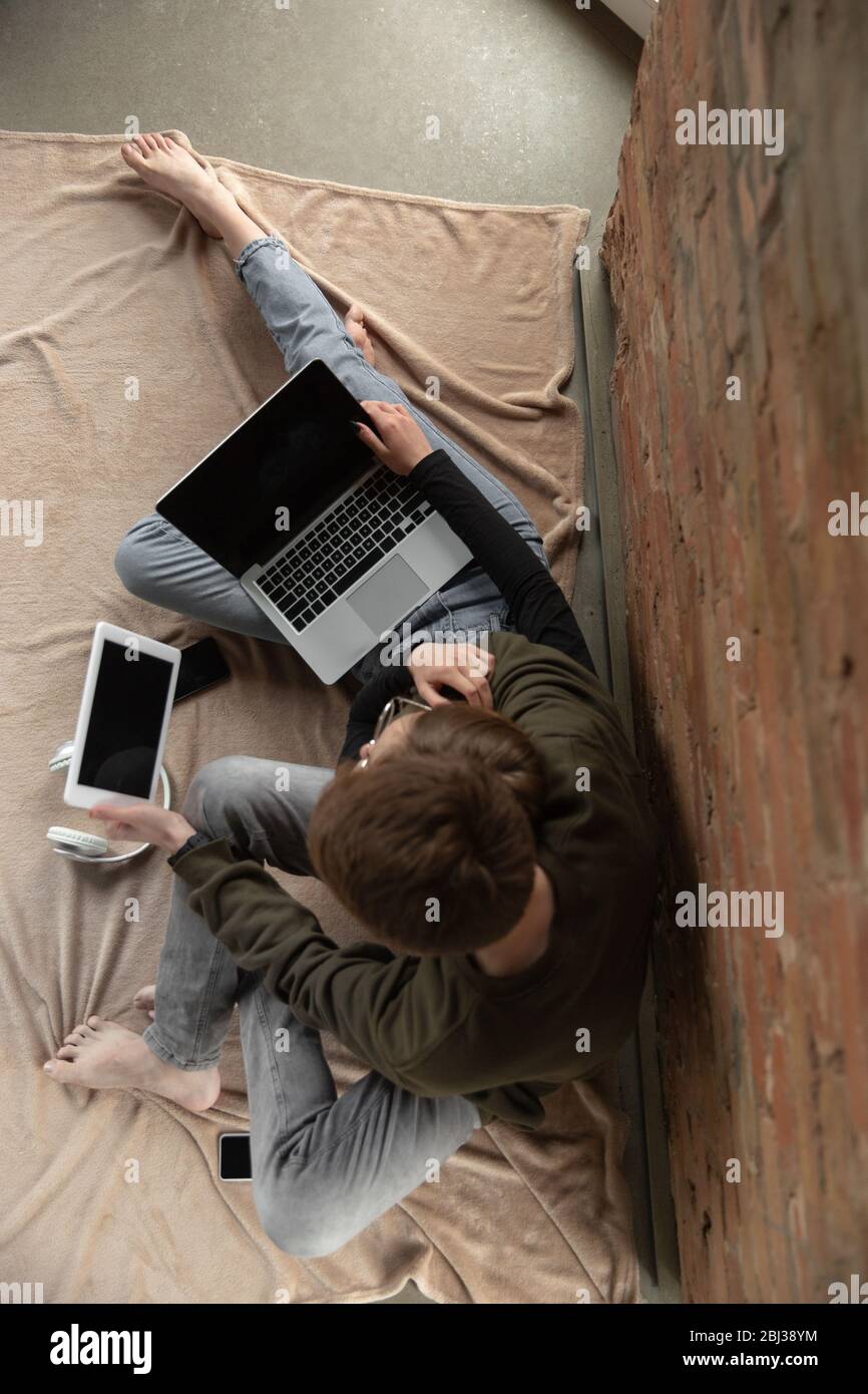 Attractive young couple using devices together, tablet, laptop ...