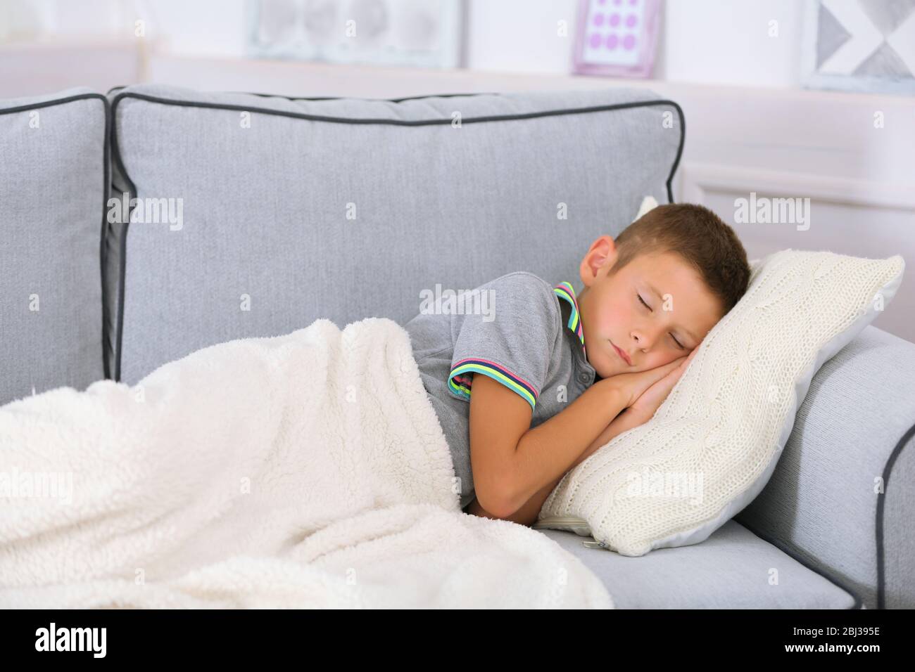 Little boy sleeping on sofa in room Stock Photo - Alamy
