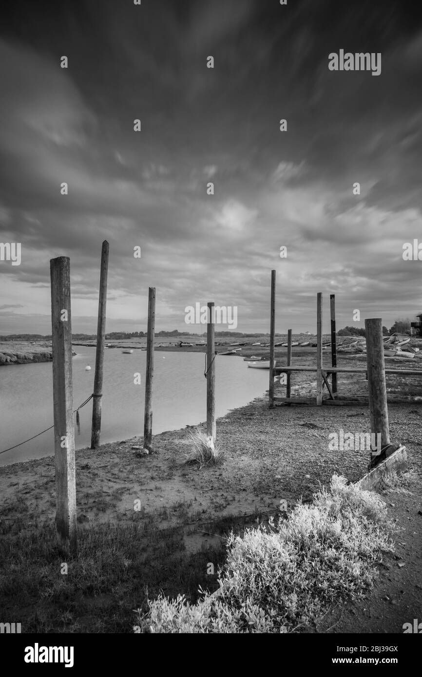 Jetty and mooring posts at Morston Quay, Norfolk, England. Black and ...
