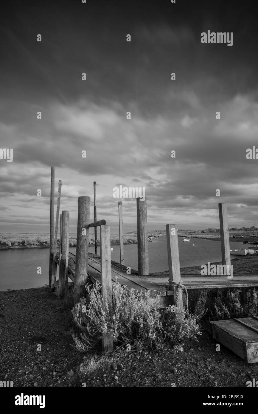 Jetty and mooring posts at Morston Quay, Norfolk, England. Black and ...