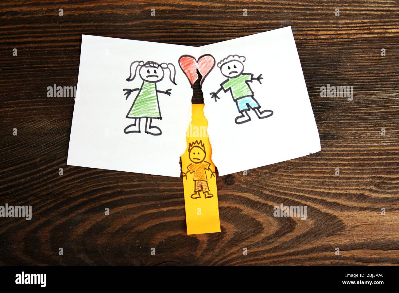 Torn apart drawing of a family on wooden background Stock Photo - Alamy