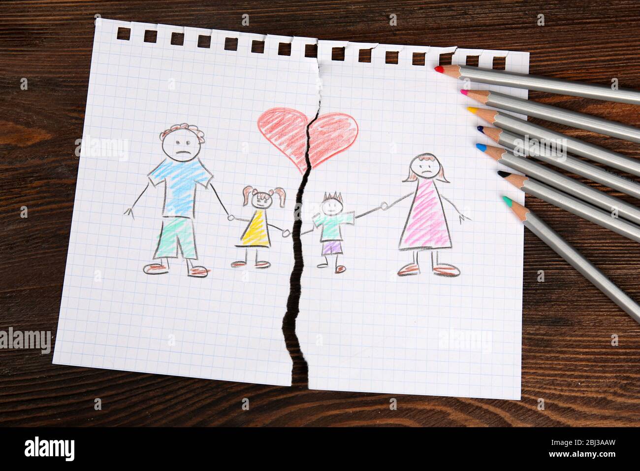 Torn apart drawing of a family on wooden background Stock Photo - Alamy