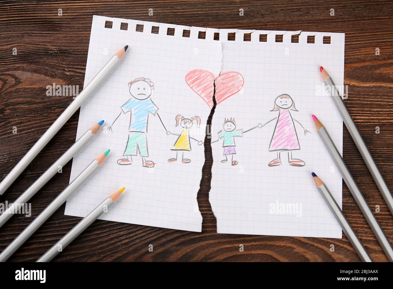 Torn apart drawing of a family on wooden background Stock Photo - Alamy