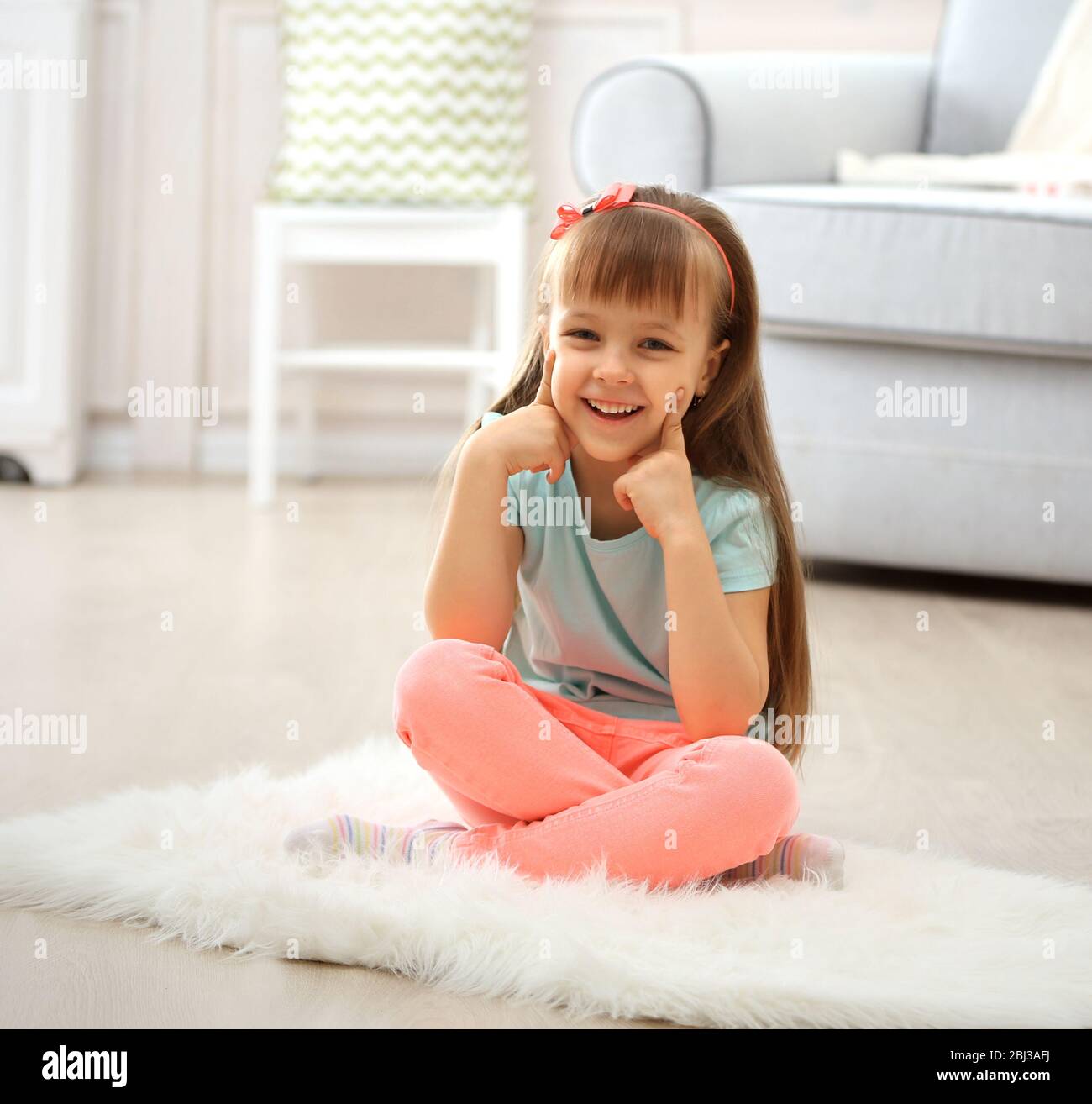 Little cute girl sitting on carpet, on home interior background Stock ...