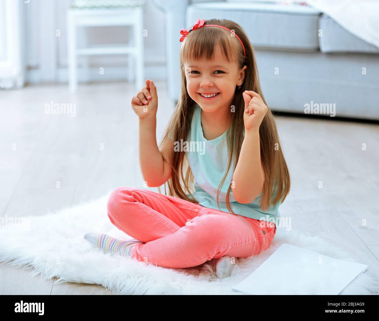 Little cute girl sitting on carpet, on home interior background Stock ...