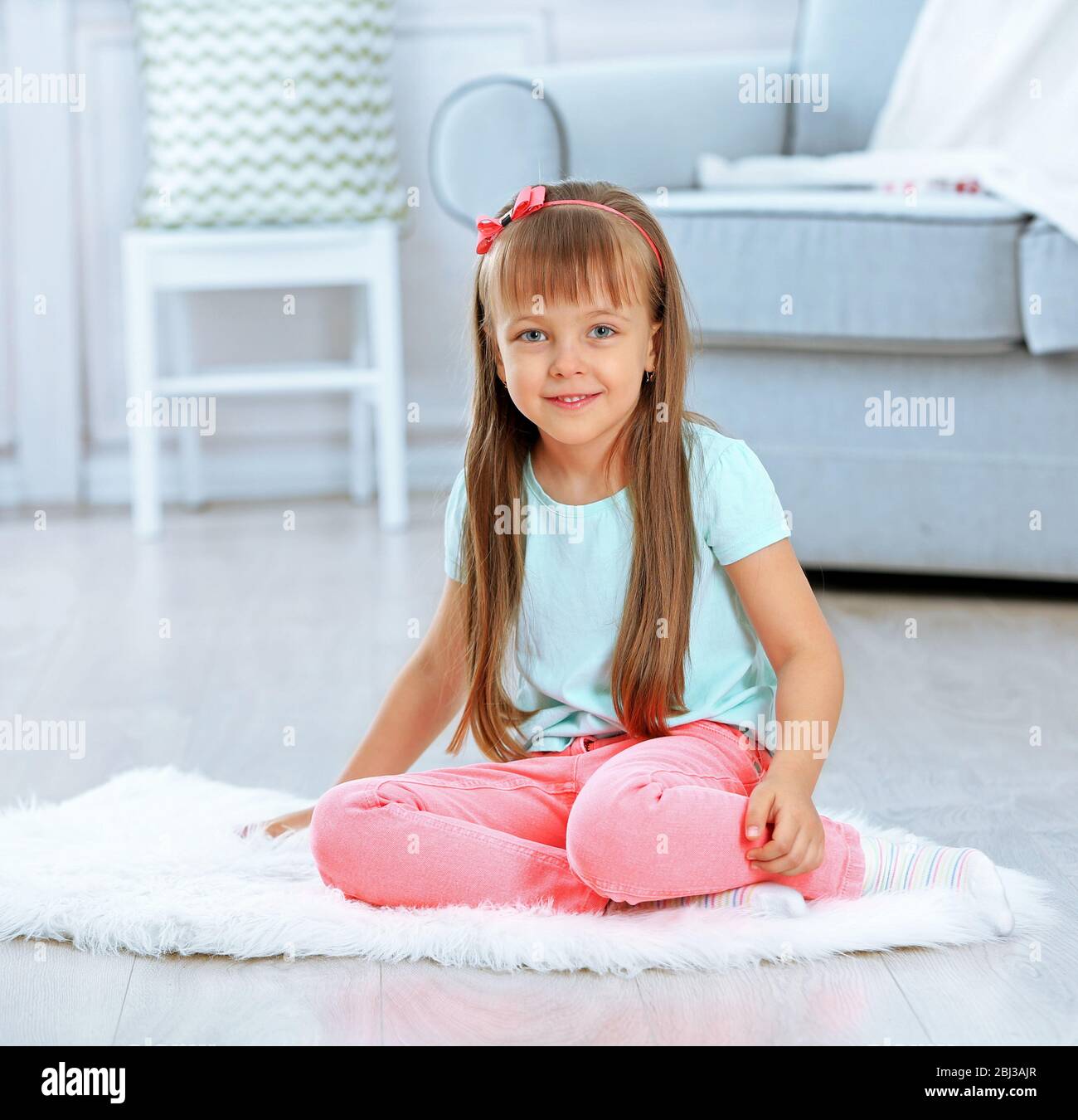 Little cute girl sitting on carpet, on home interior background Stock ...
