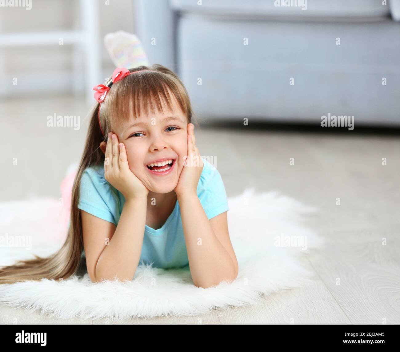 Little cute girl lying on carpet, on home interior background Stock ...
