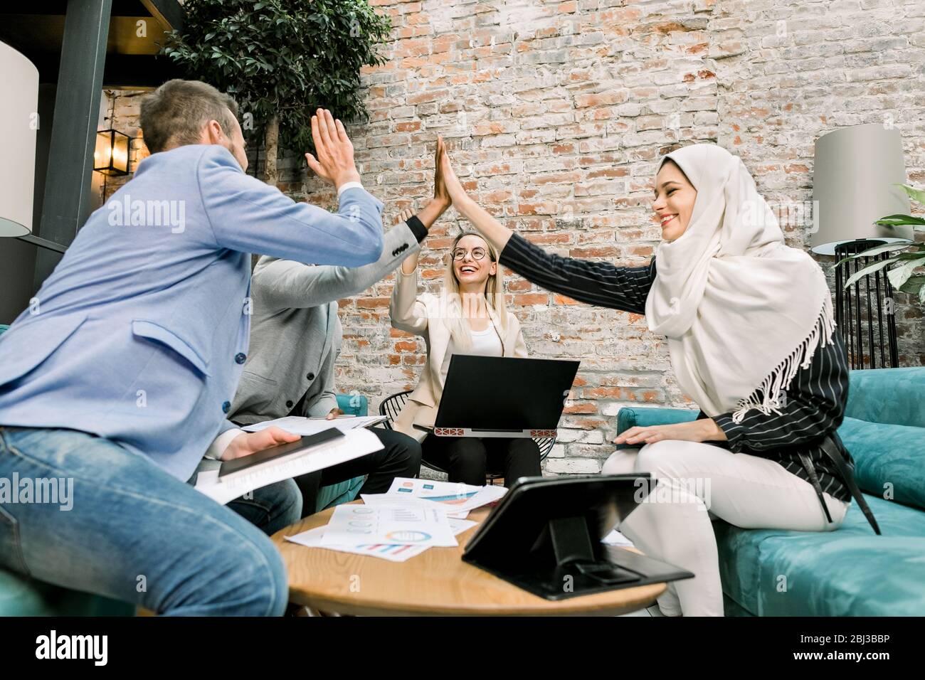Teamwork successful high five together. Four young multiethnical male ...