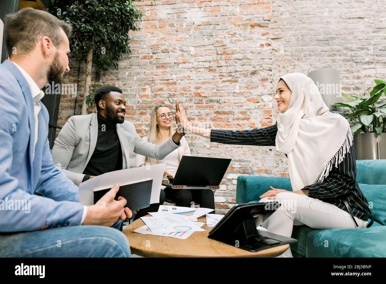 High-five for success concept. Diverse group of smiling happy ...