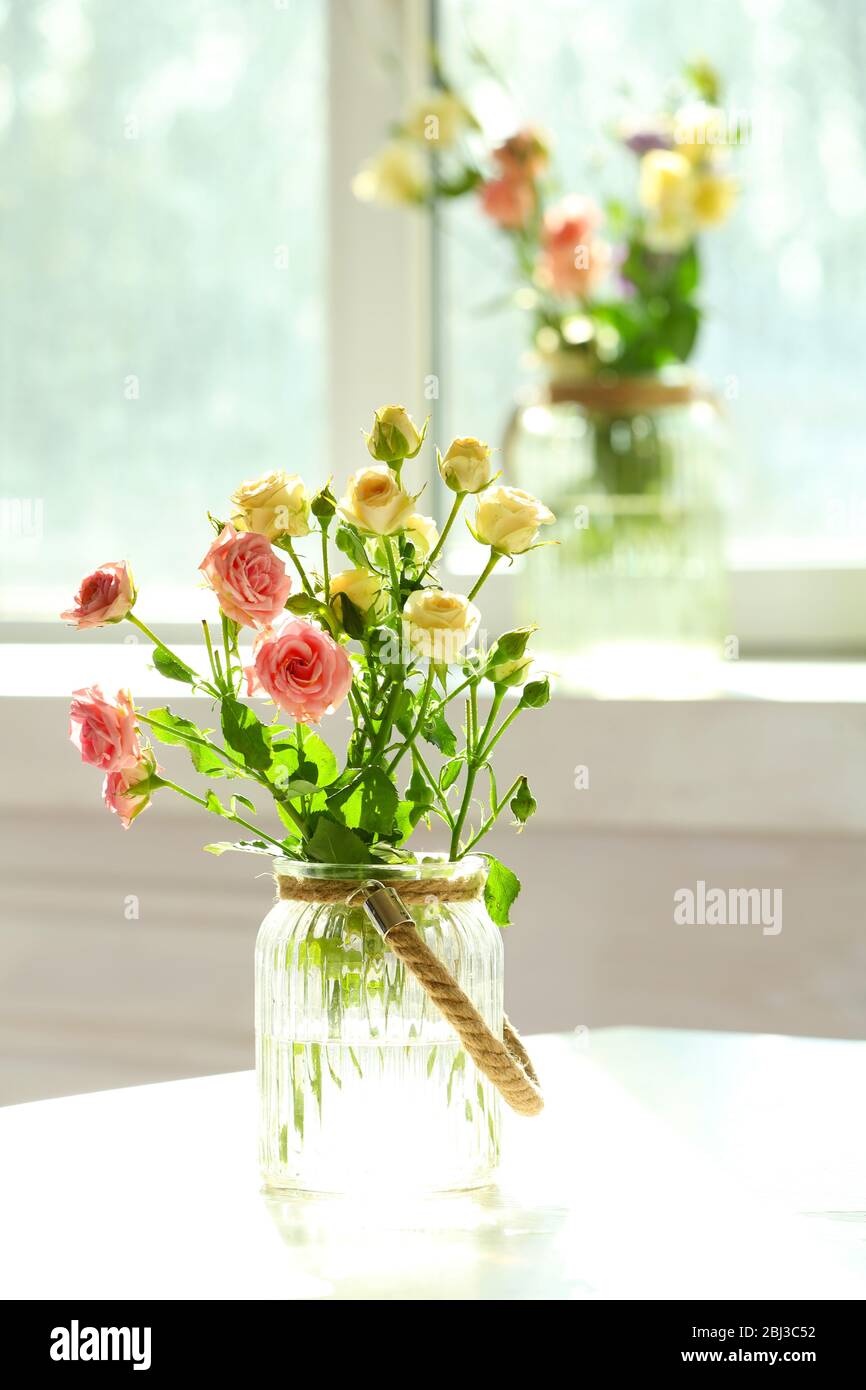 Beautiful spring flowers in vase on window background Stock Photo - Alamy