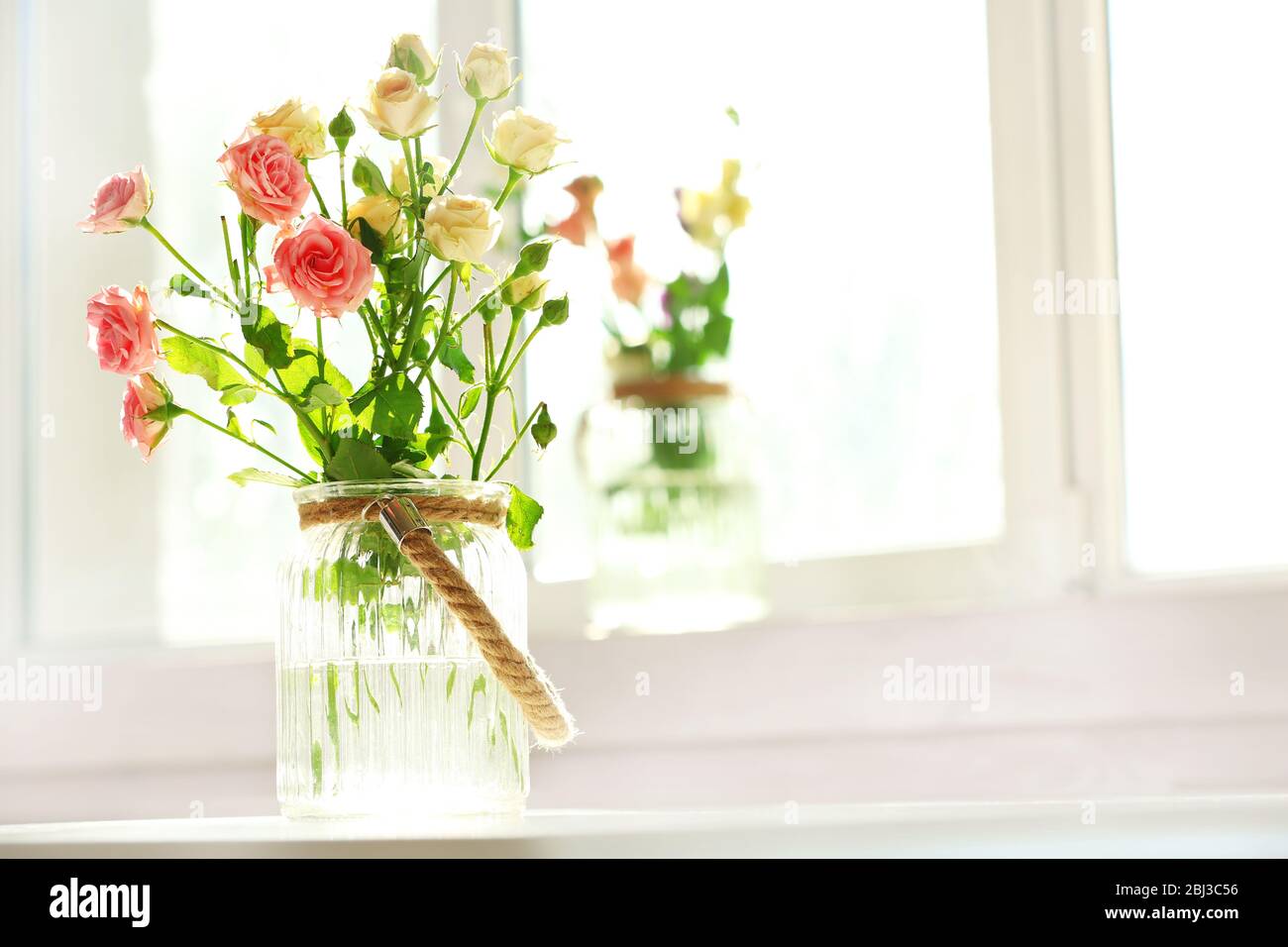Beautiful spring flowers in vase on window background Stock Photo - Alamy