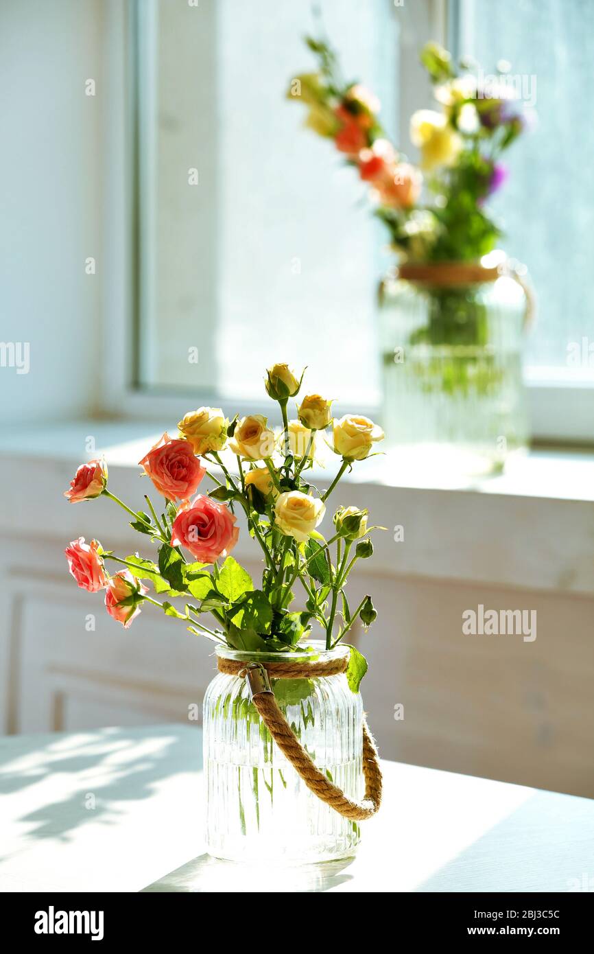 Beautiful spring flowers in vase on window background Stock Photo - Alamy