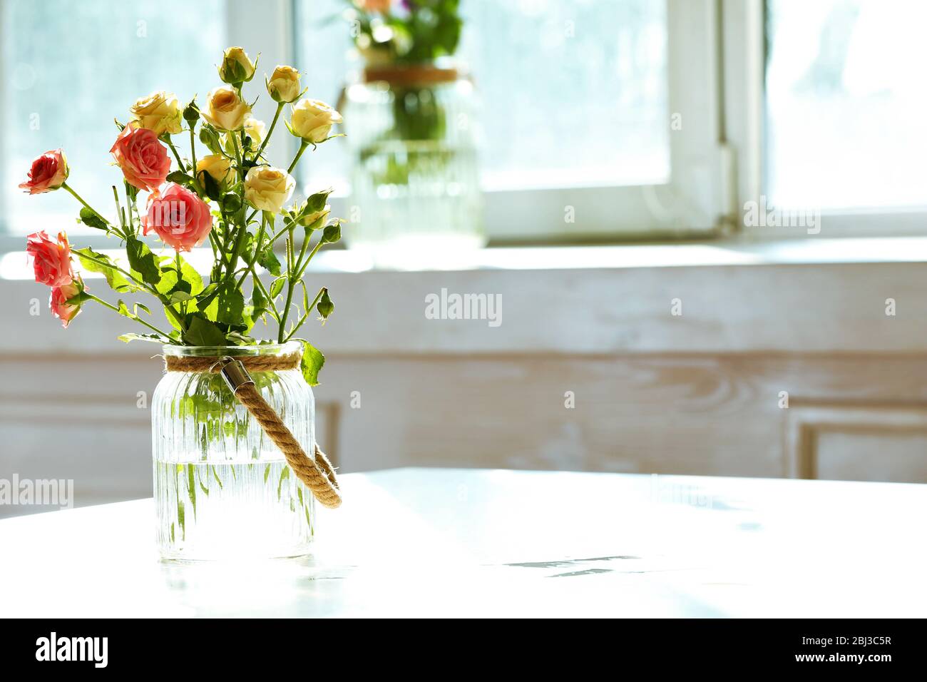 Beautiful spring flowers in vase on window background Stock Photo - Alamy