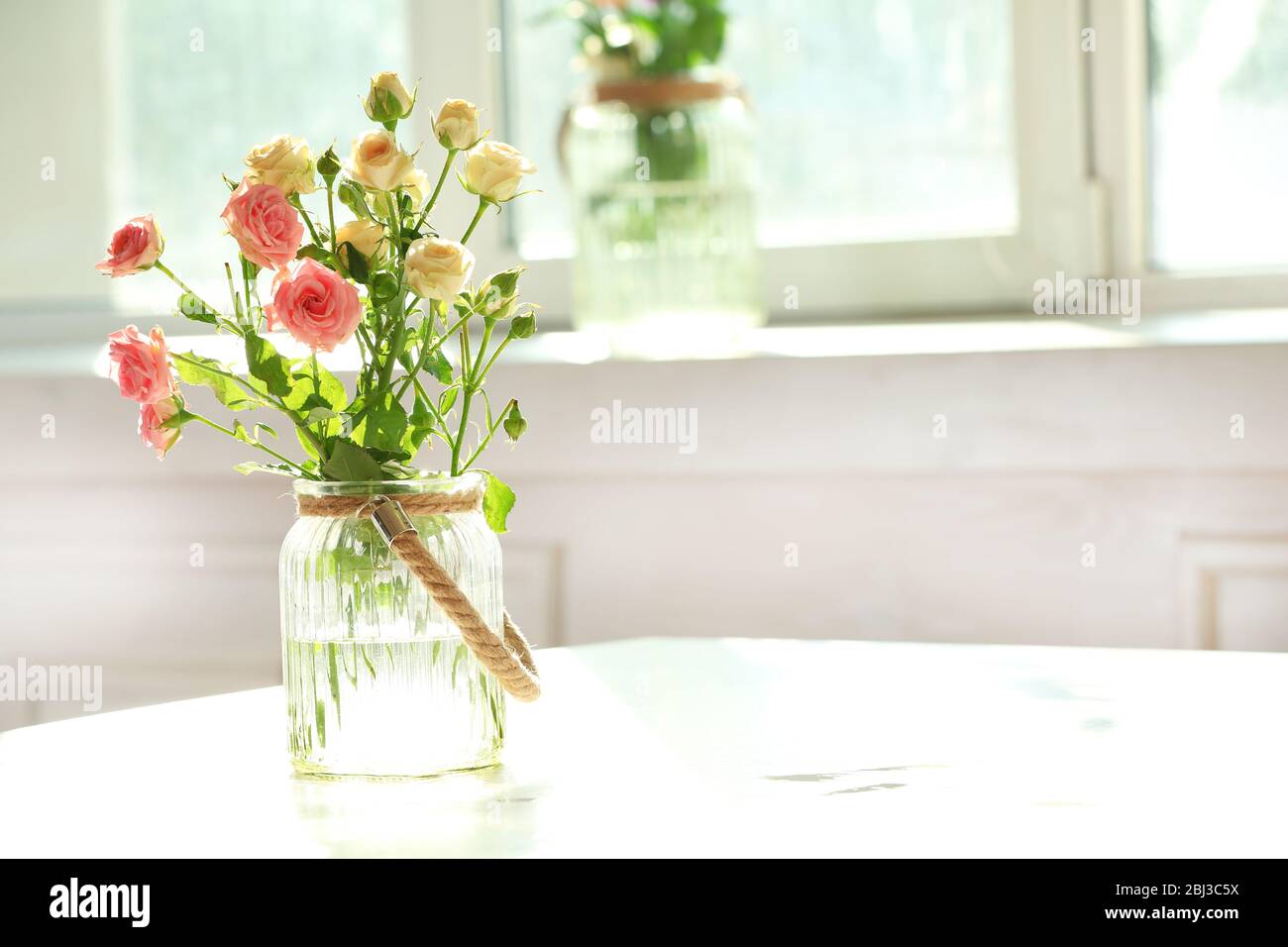 Beautiful spring flowers in vase on window background Stock Photo - Alamy