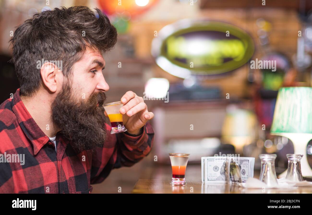 Man with cheerful face sit alone at bar counter. Hipster holds glass ...
