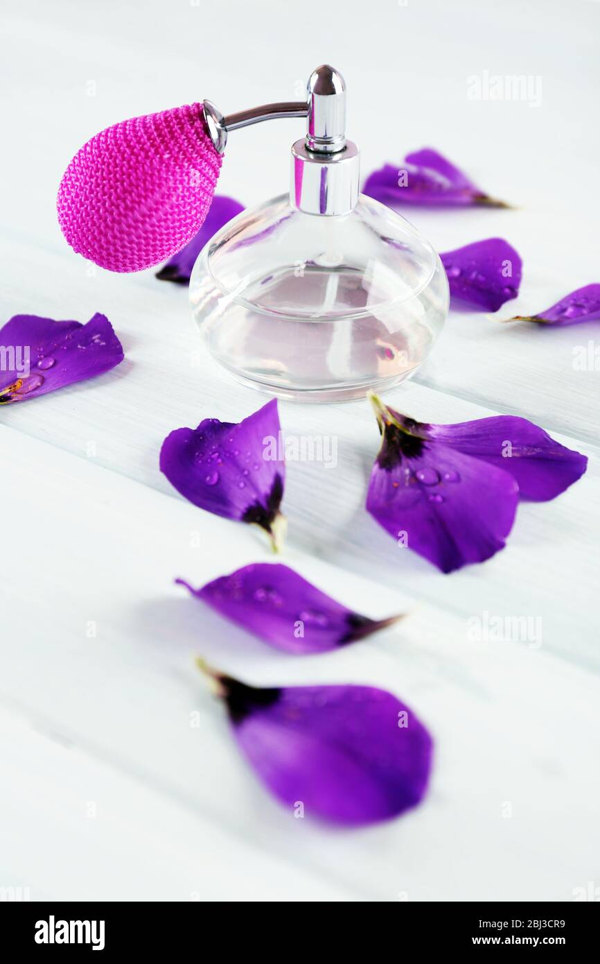 Bottle of perfume and flowers petals on wooden background Stock Photo ...