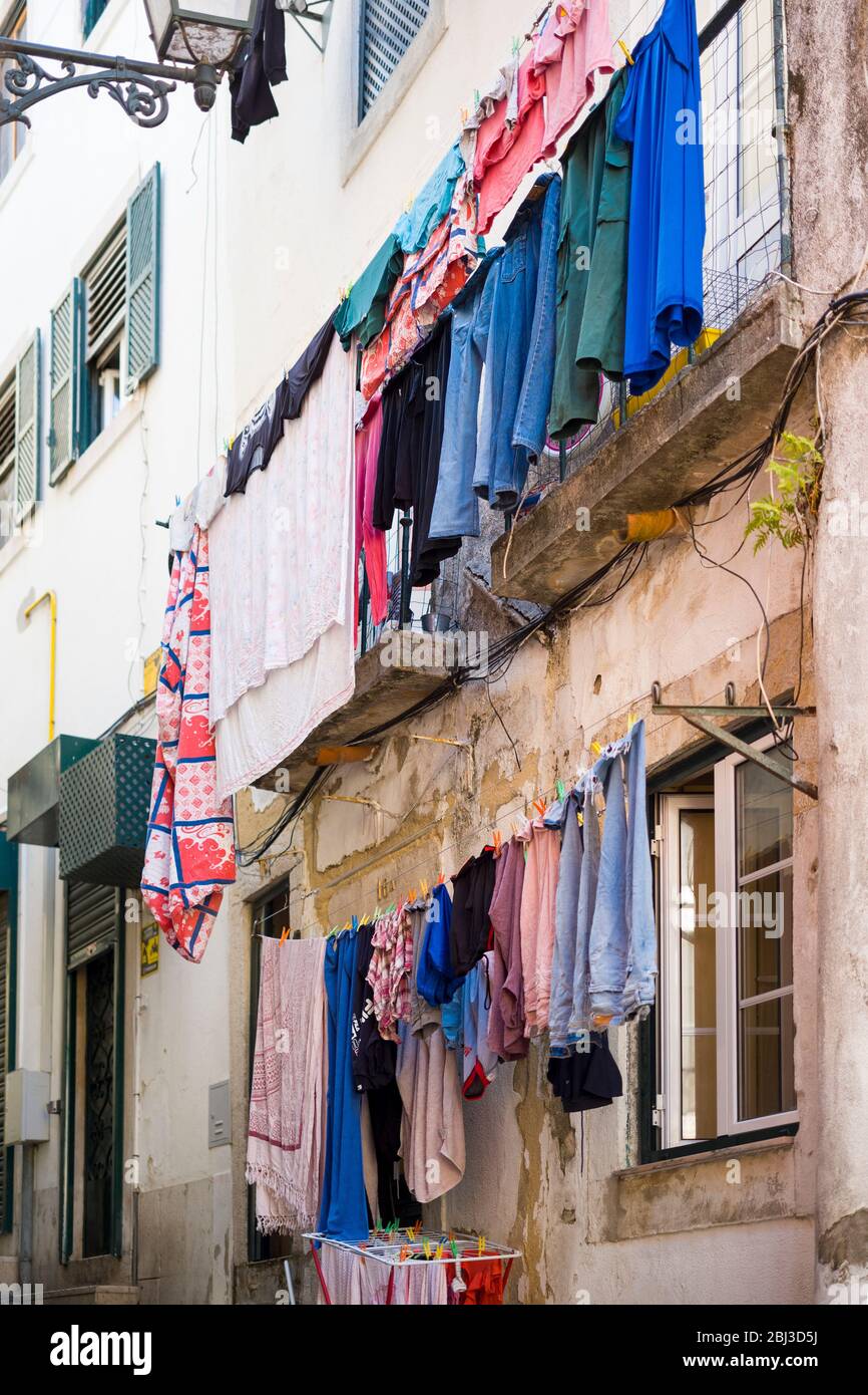 Typical Portugese steep street scene, laundry hanging to dry on washing ...