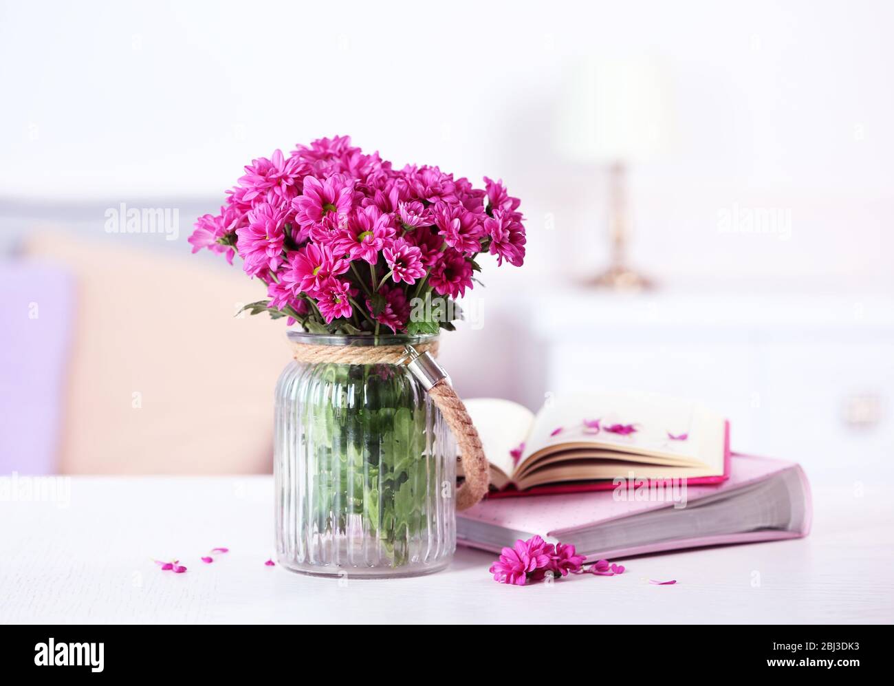 Beautiful flowers in vase on table in room Stock Photo - Alamy