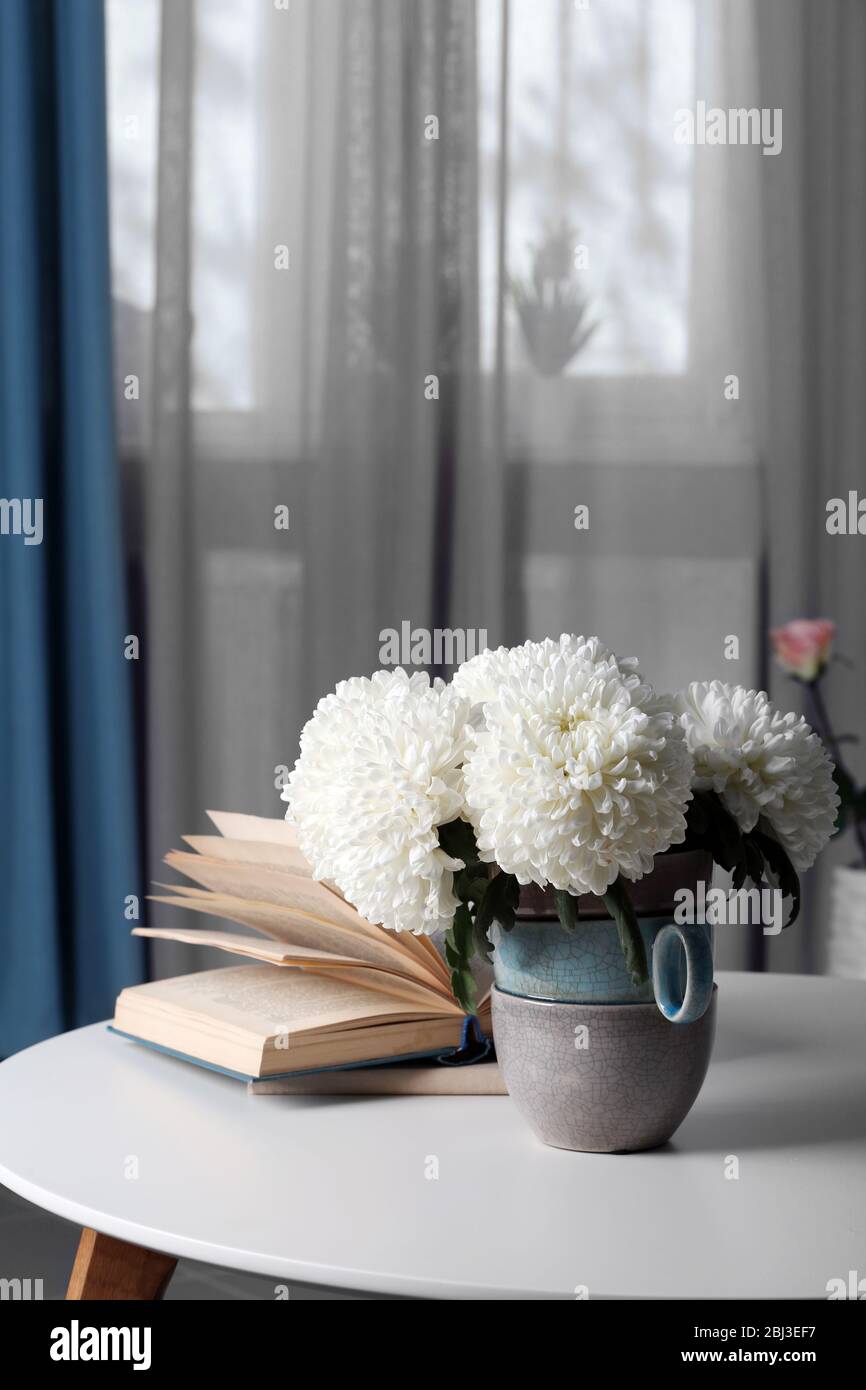 Beautiful flowers in vase on table in room Stock Photo - Alamy