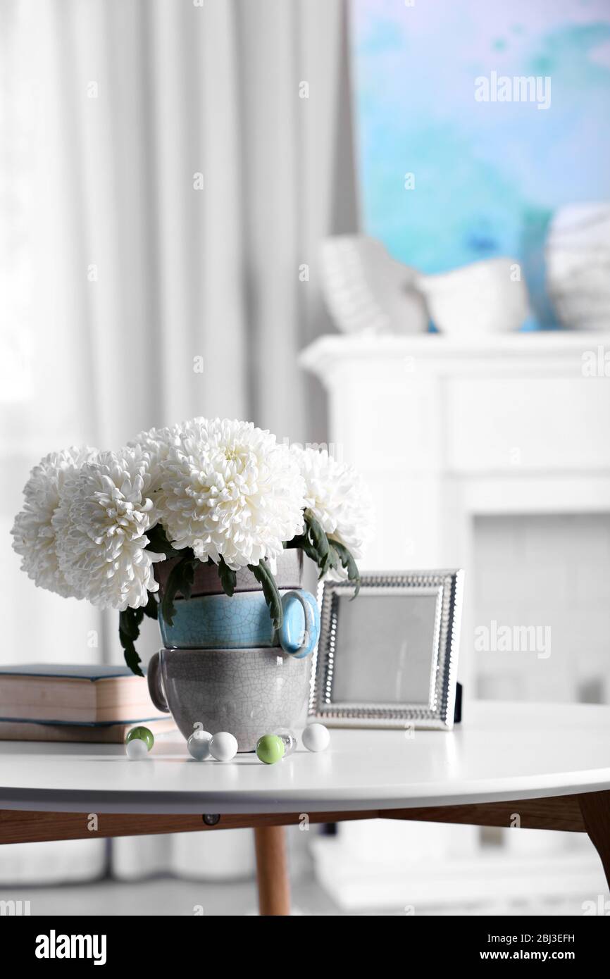 Beautiful flowers in vase on table in room Stock Photo - Alamy