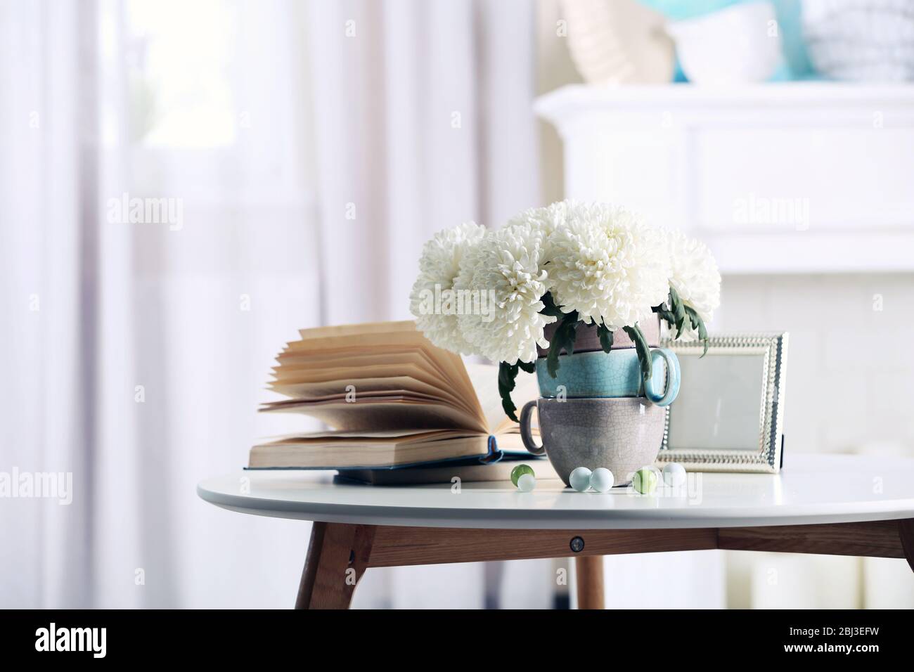 Beautiful flowers in vase on table in room Stock Photo - Alamy