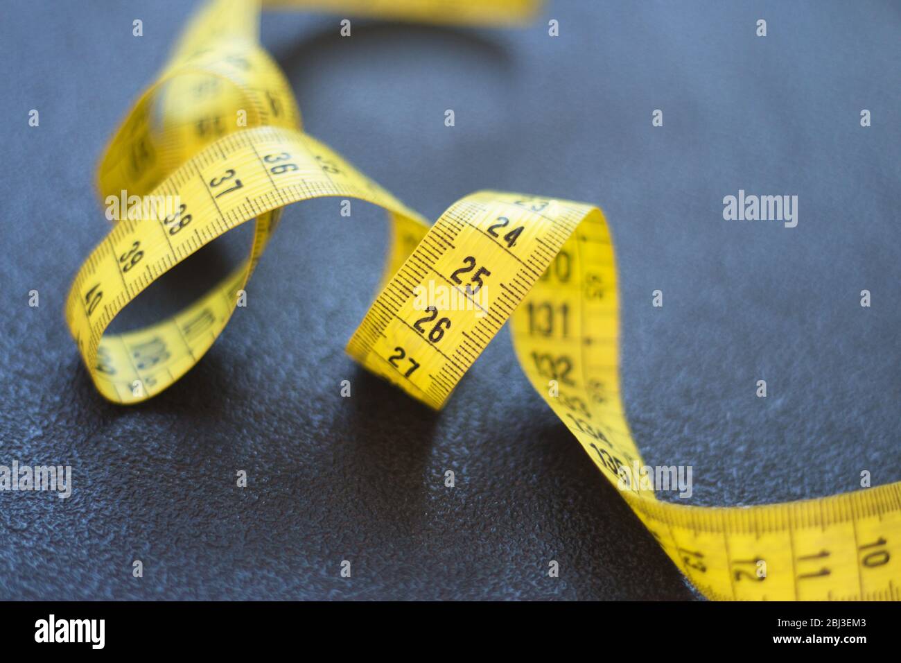 Flexible tape measure on dark floor. No people Stock Photo - Alamy