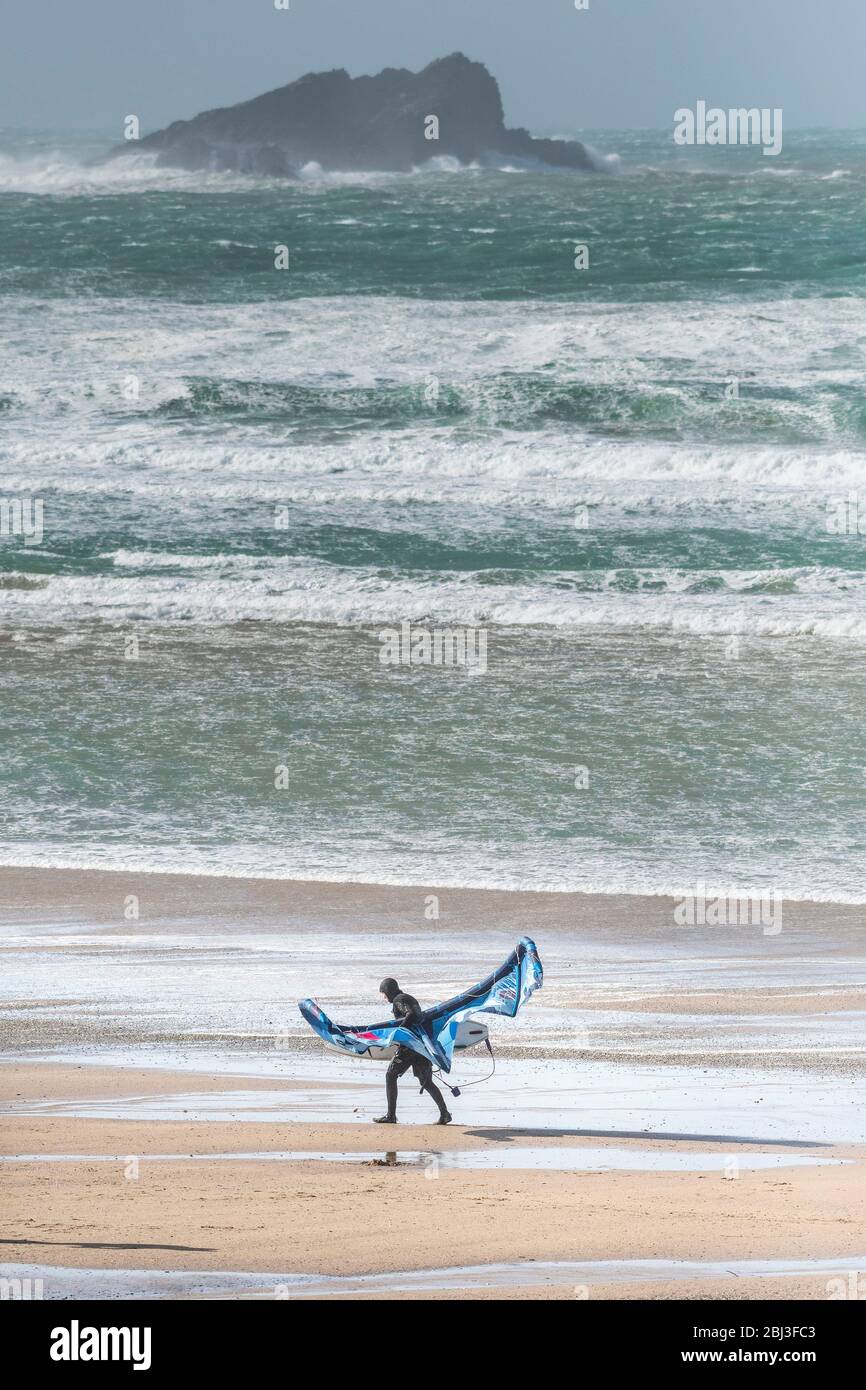 A lone kite boarder surfer struggling to carry his kite boarding ...