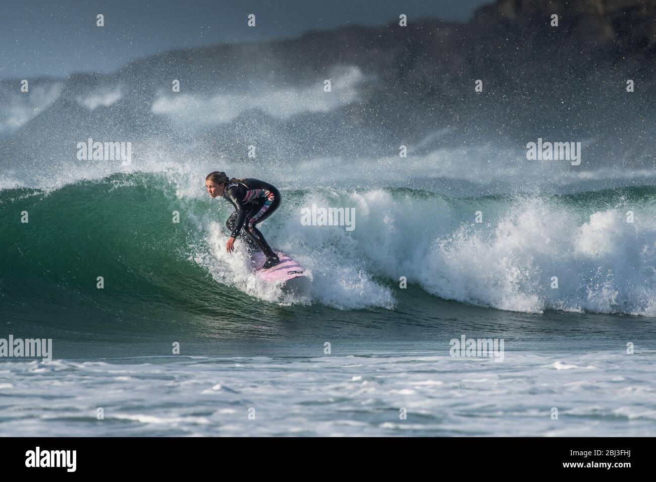 Spectacular surfing action as a young female surfer rides a wave at ...