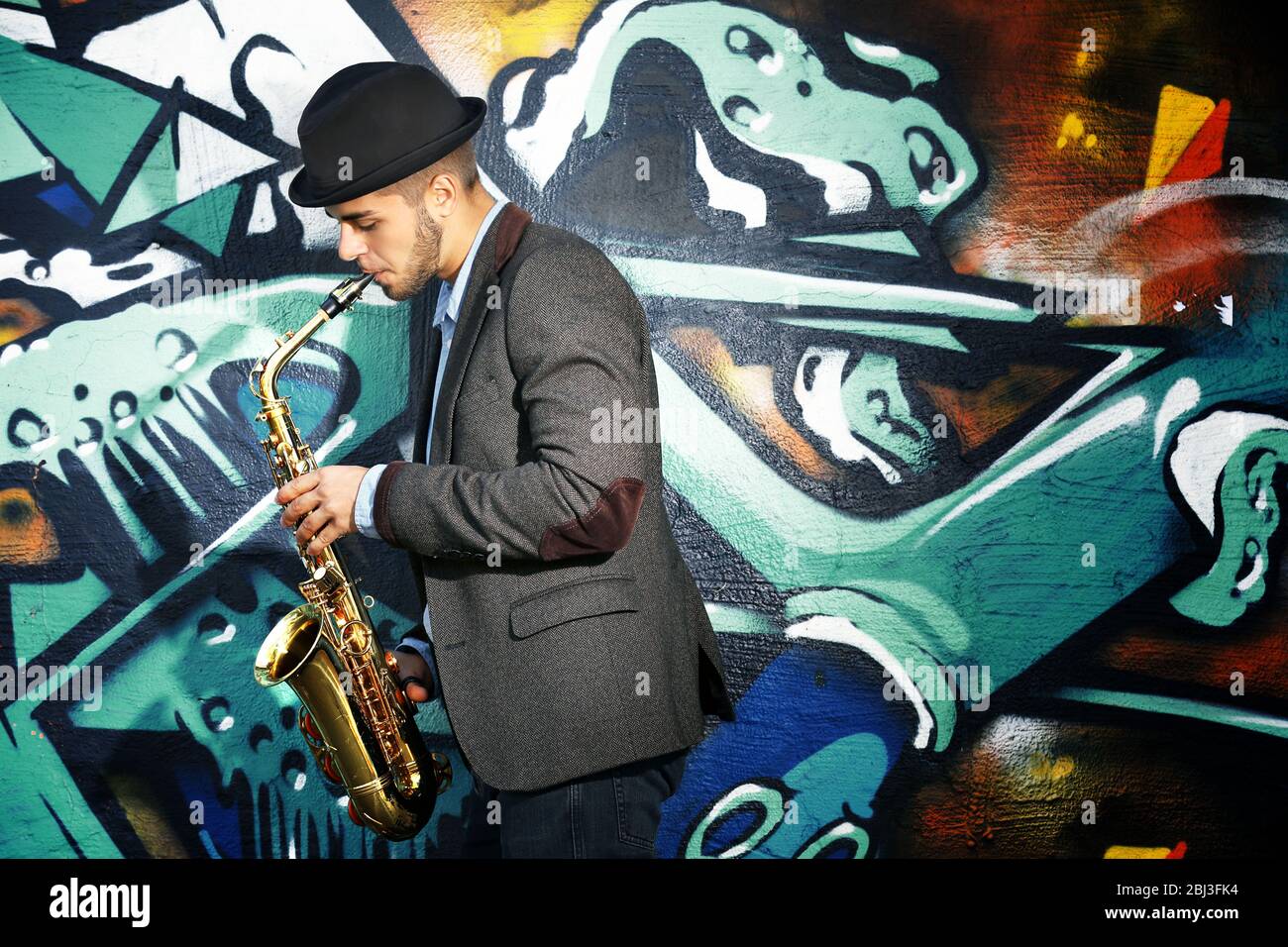 Saxophone player on graffiti wall background Stock Photo - Alamy