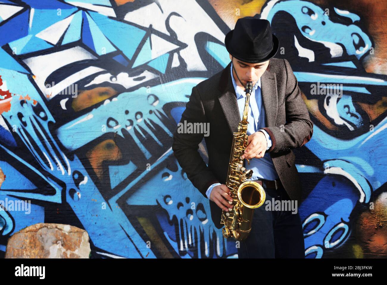 Saxophone player on graffiti wall background Stock Photo - Alamy