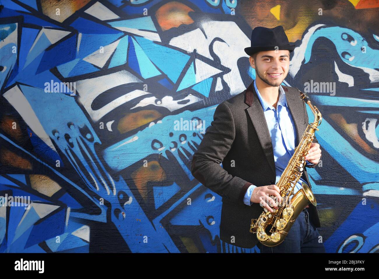 Saxophone player on graffiti wall background Stock Photo - Alamy