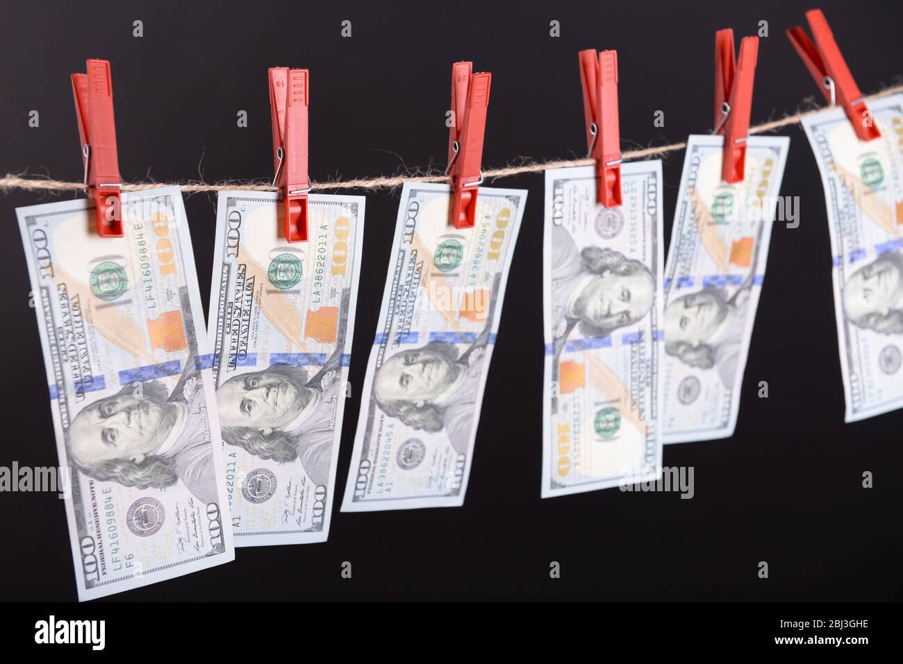 Concept of money laundering - dollars are drying on red clips on cord ...