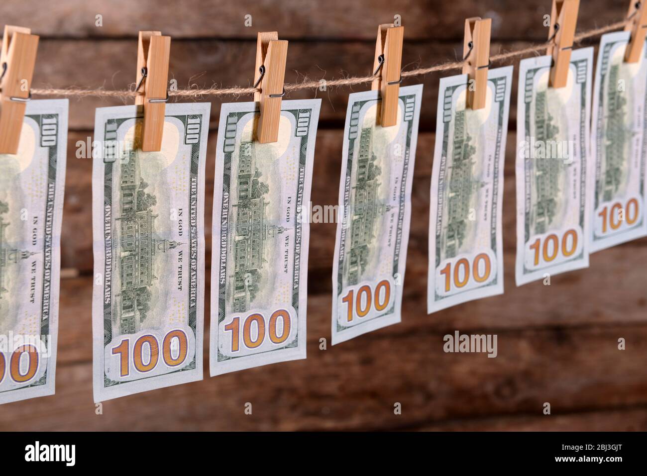 Concept of money laundering - dollars are drying on cord on wooden ...