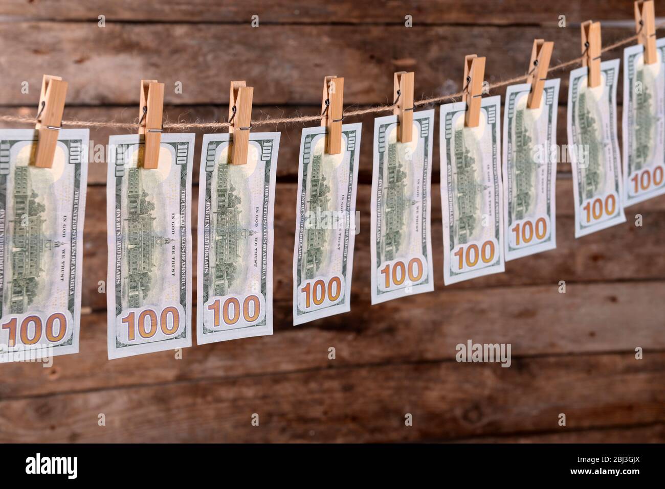 Concept of money laundering - dollars are drying on cord on wooden ...