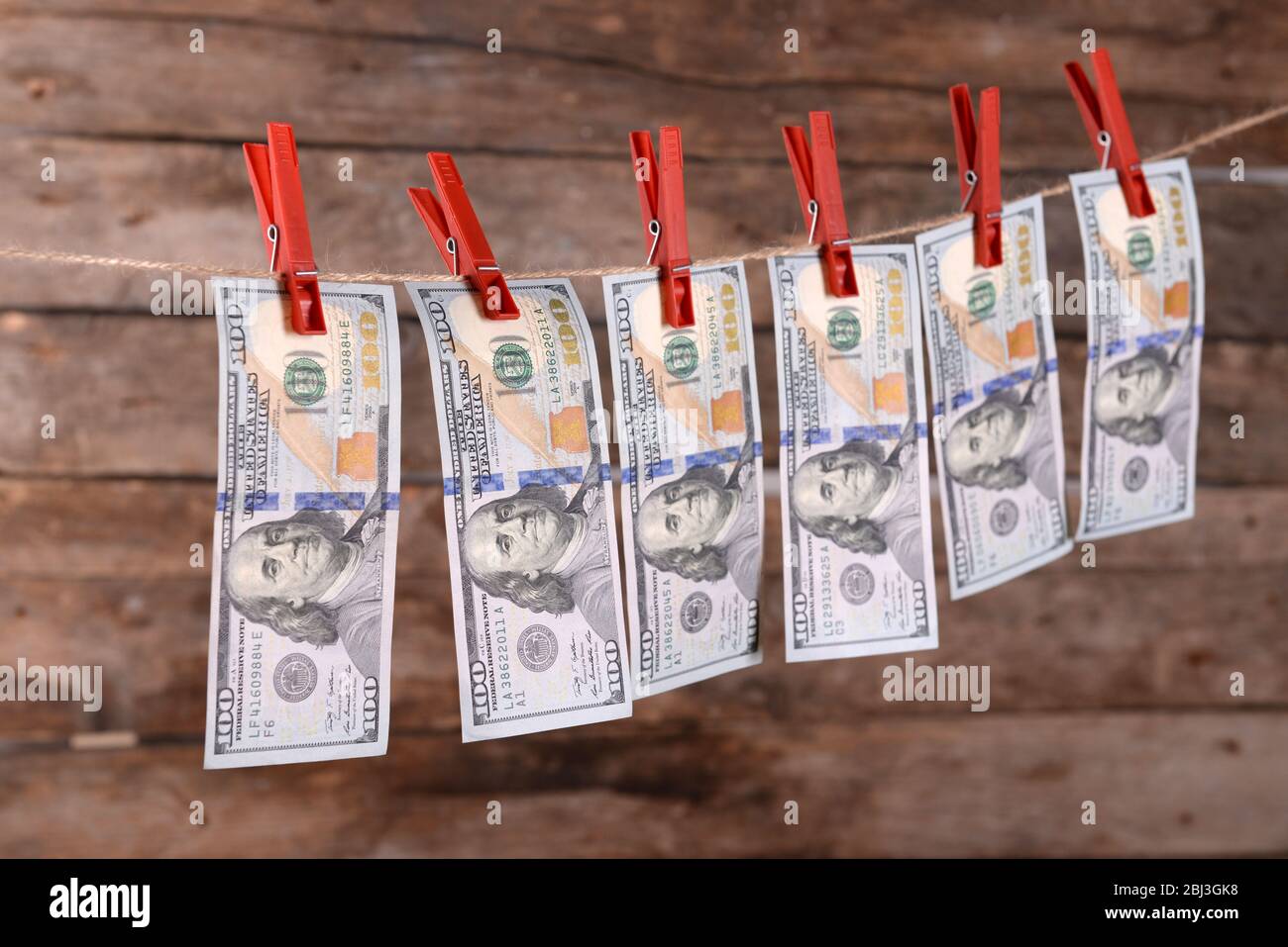 Concept of money laundering - dollars are drying on cord on wooden ...