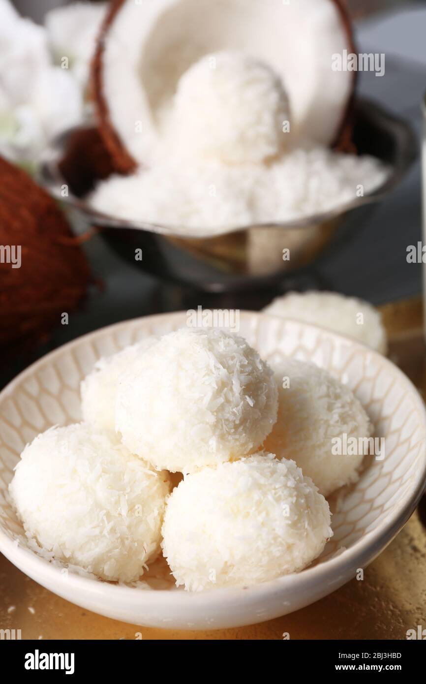 Homemade Candies in coconut flakes and fresh coconut on light ...