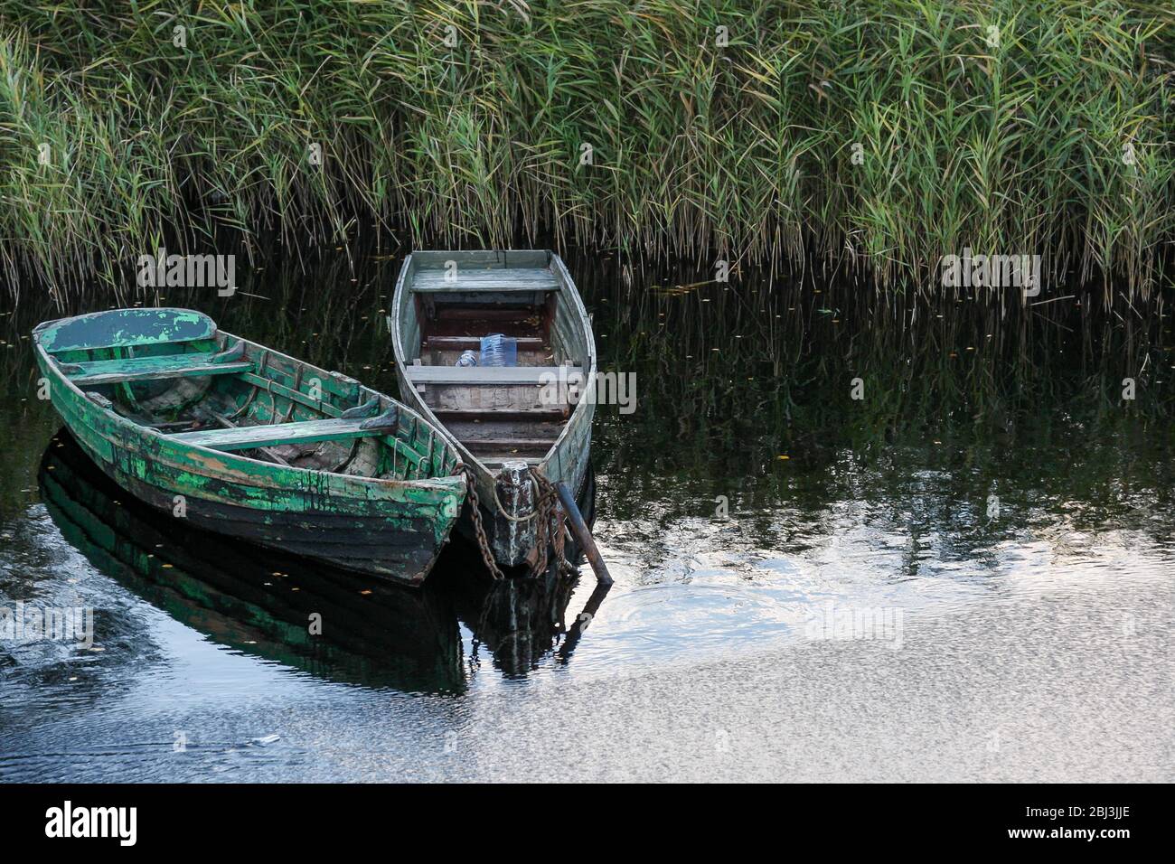 Very old rustic rowboats in water Stock Photo - Alamy
