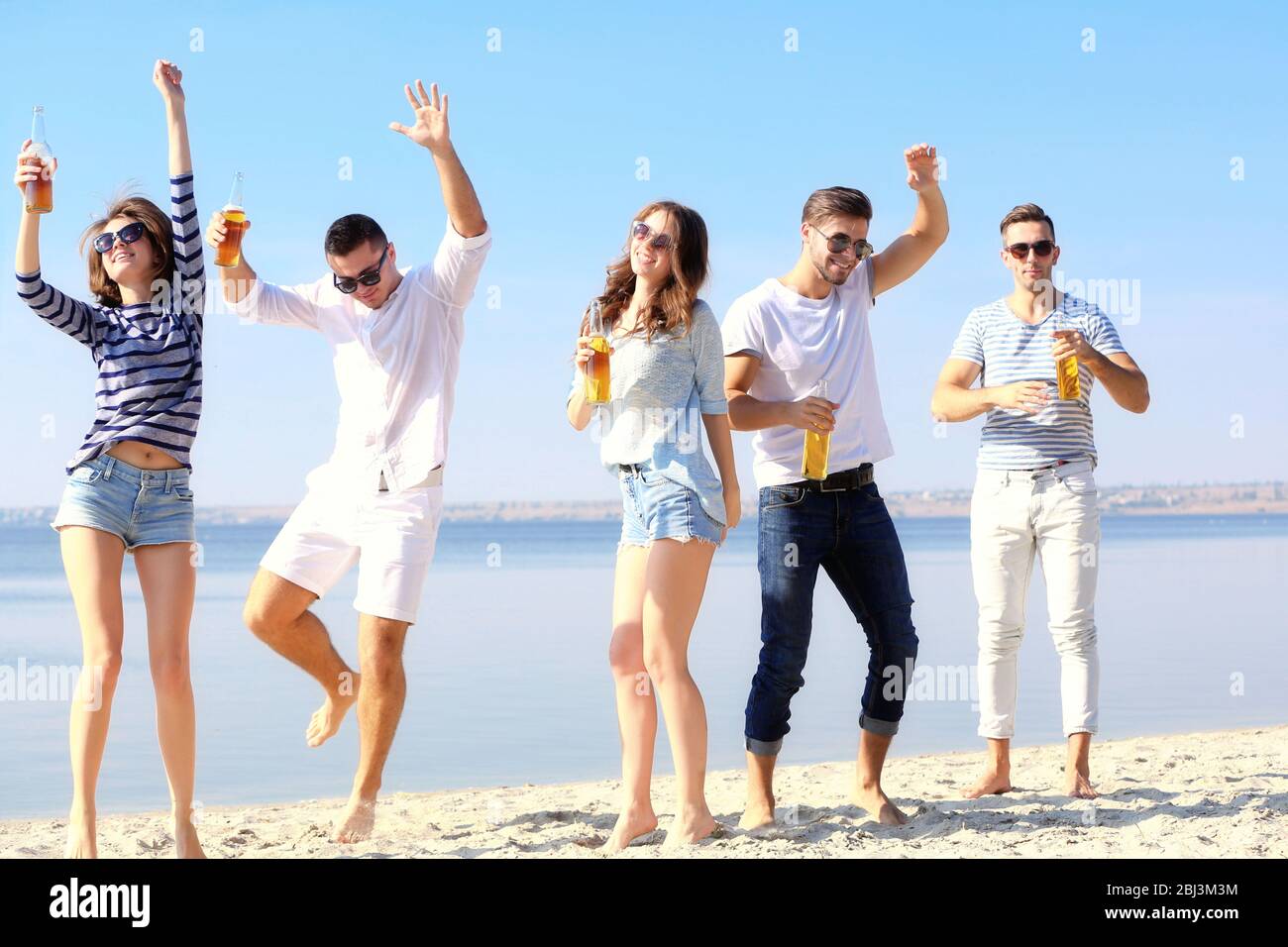 Young people with beer on the riverside Stock Photo - Alamy