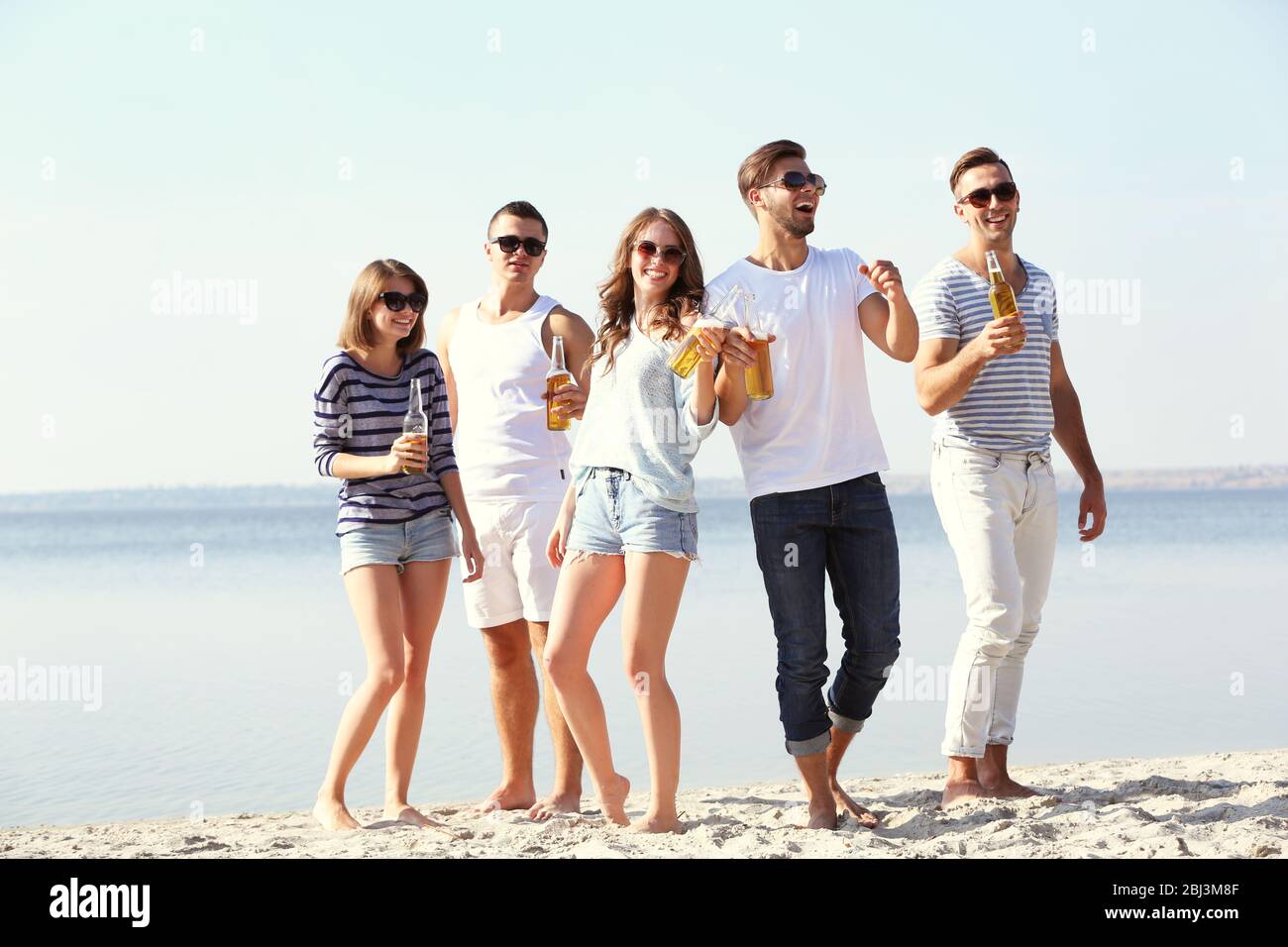 Young people with beer on the riverside Stock Photo - Alamy